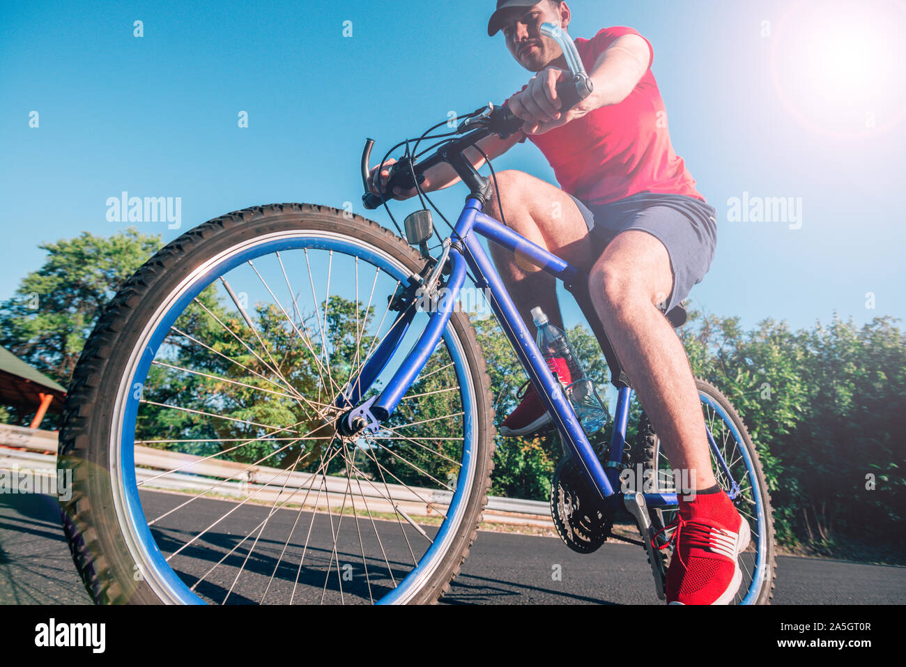 Fit male biker cyclist riding his bike cycle on an asphalt road at ...