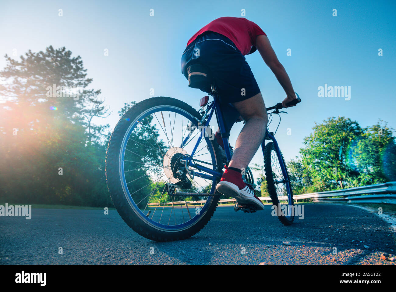 Fit male biker cyclist riding his bike cycle on an asphalt road at ...