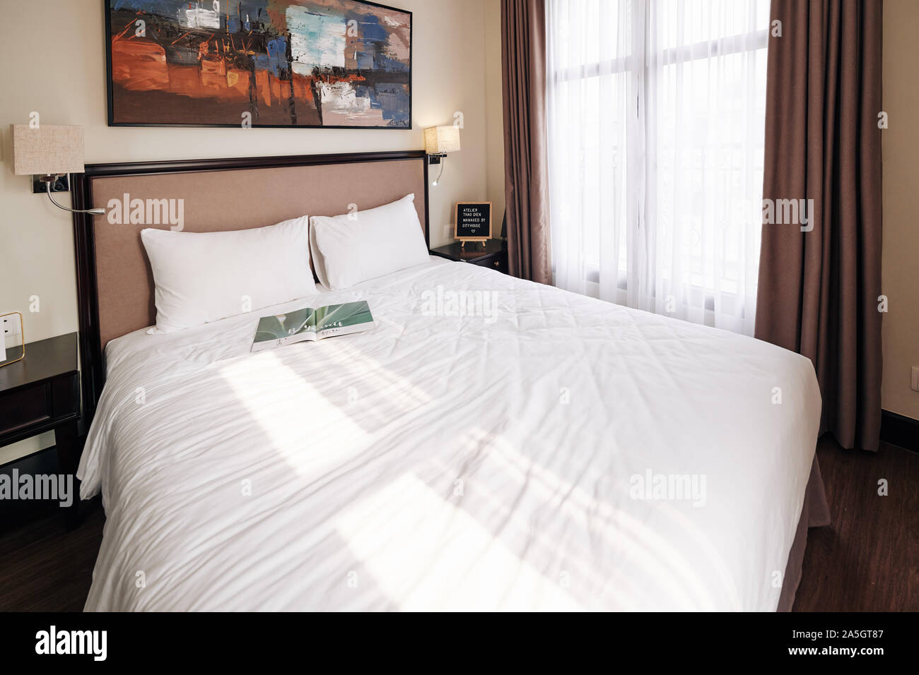 Queen size bed with opened magazine in beautiful suite ready for new ...