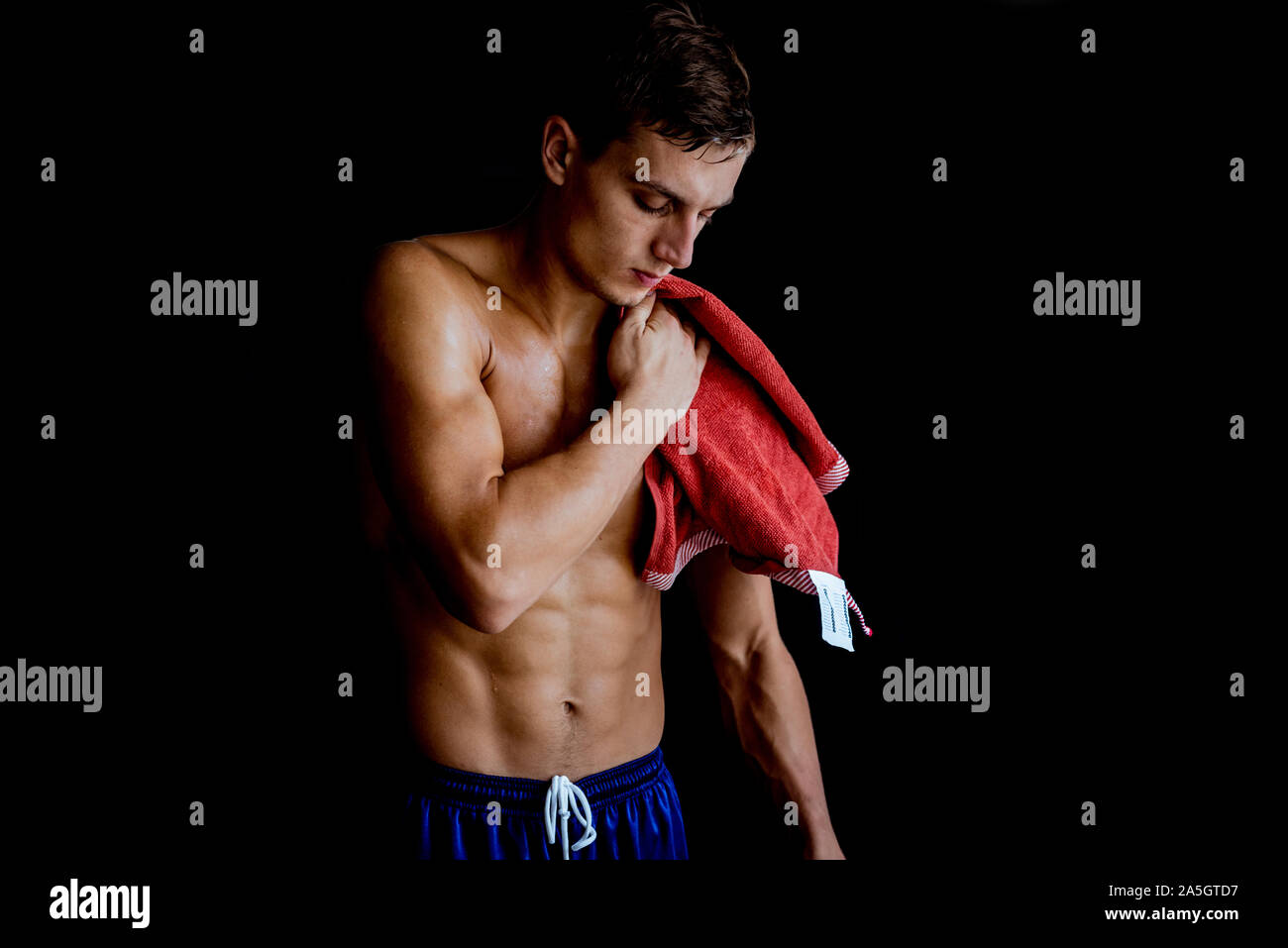 Muscular man wiping sweat from arms after exercise in the gym Stock ...