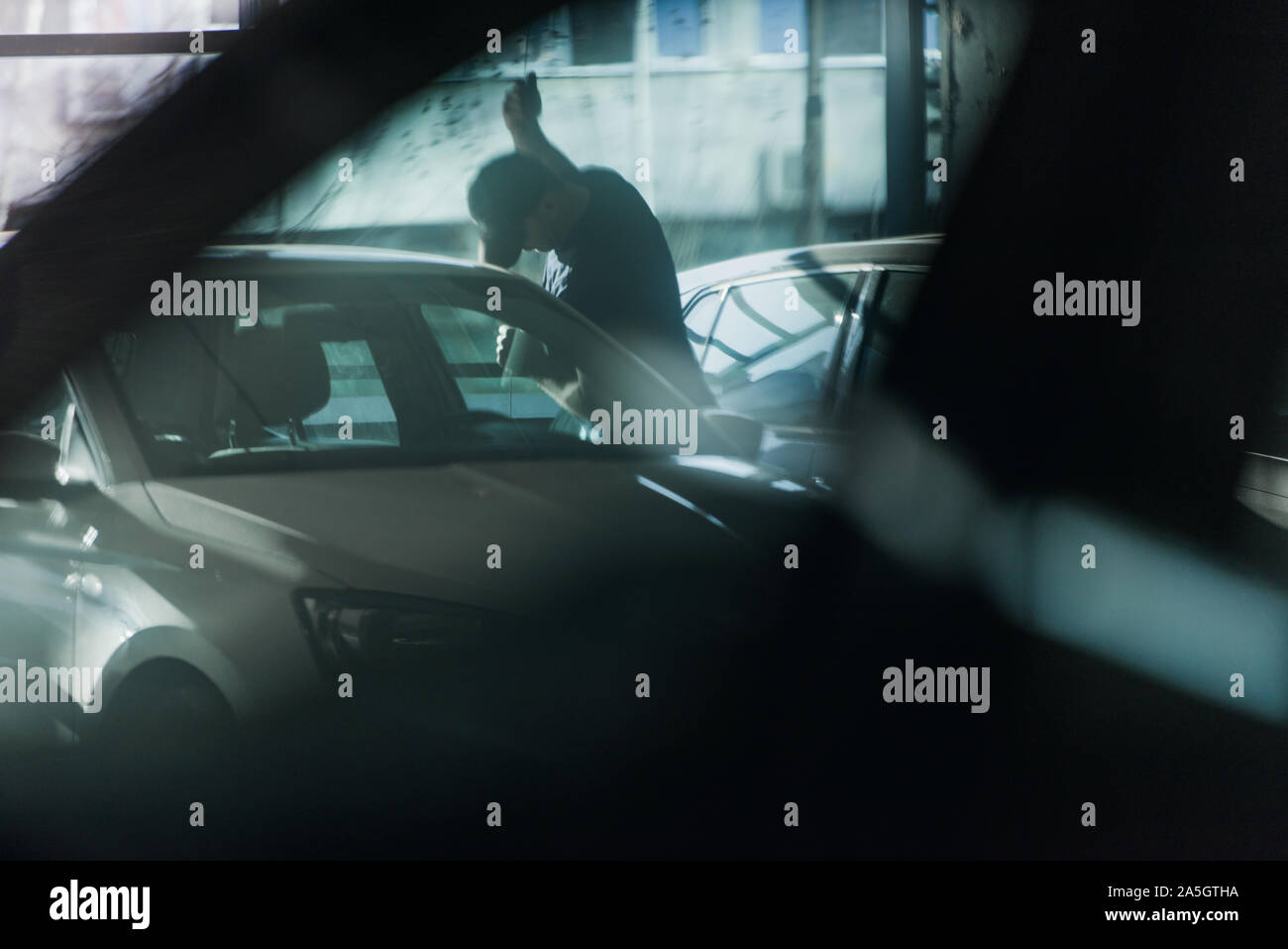 Young bandit is stealing white parking car with crowbar tool Stock ...