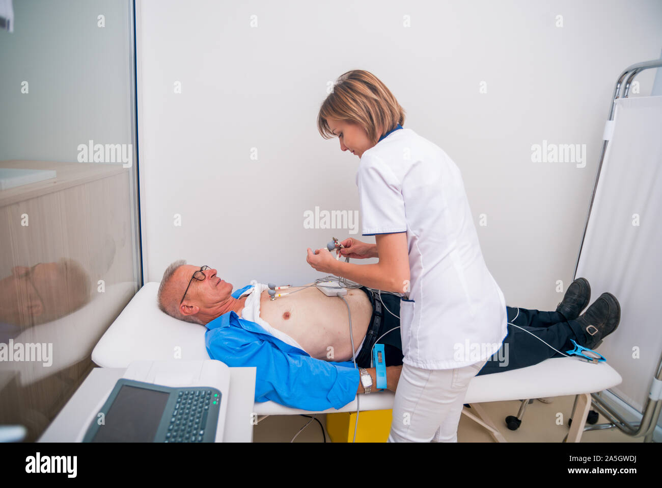 Female(doctor) nurse performs EKG test on an older man Stock Photo - Alamy