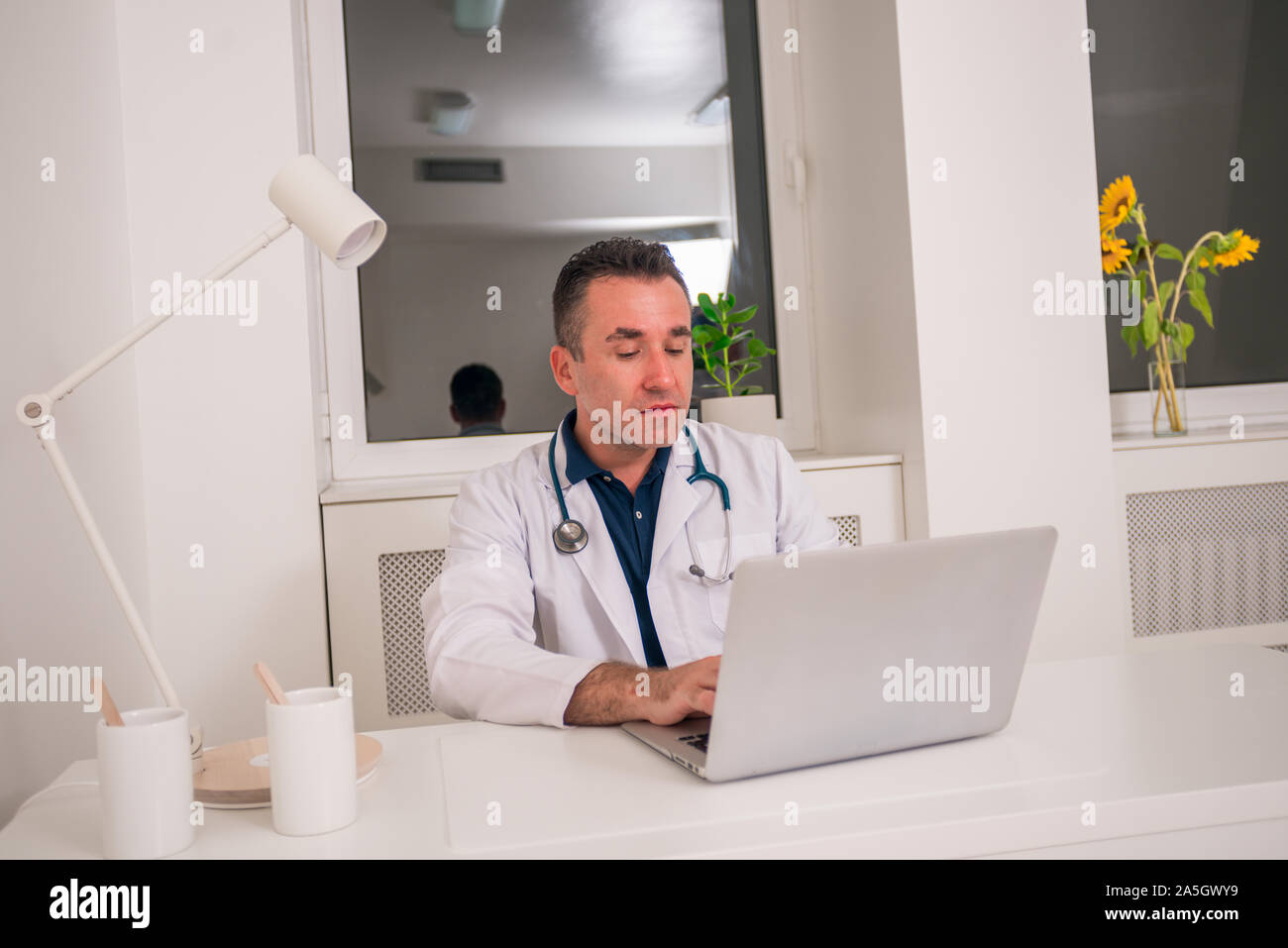 Portrait of Doctor specialist sitting on a chair at his desk while ...