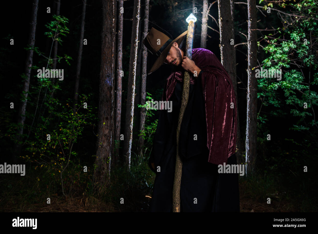 Wizard cosplay with glowing staff and hand during night time in the ...