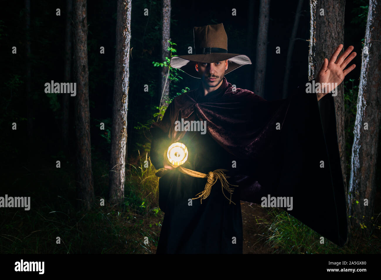 Man who is wearing wizard robes and casting glow spell with his magic ...
