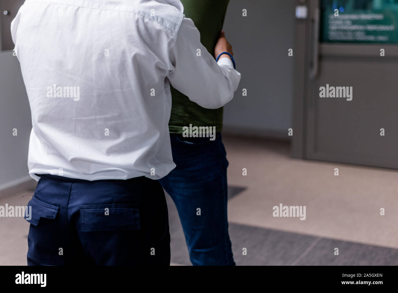 Man being body searched for hidden objects by a guard at security ...