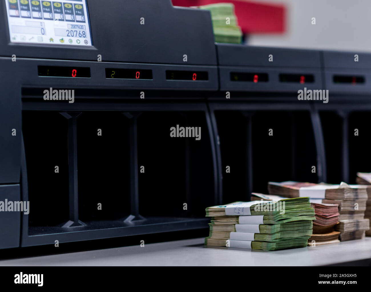 Banknotes sorted into groups placed on the table in front of machines ...