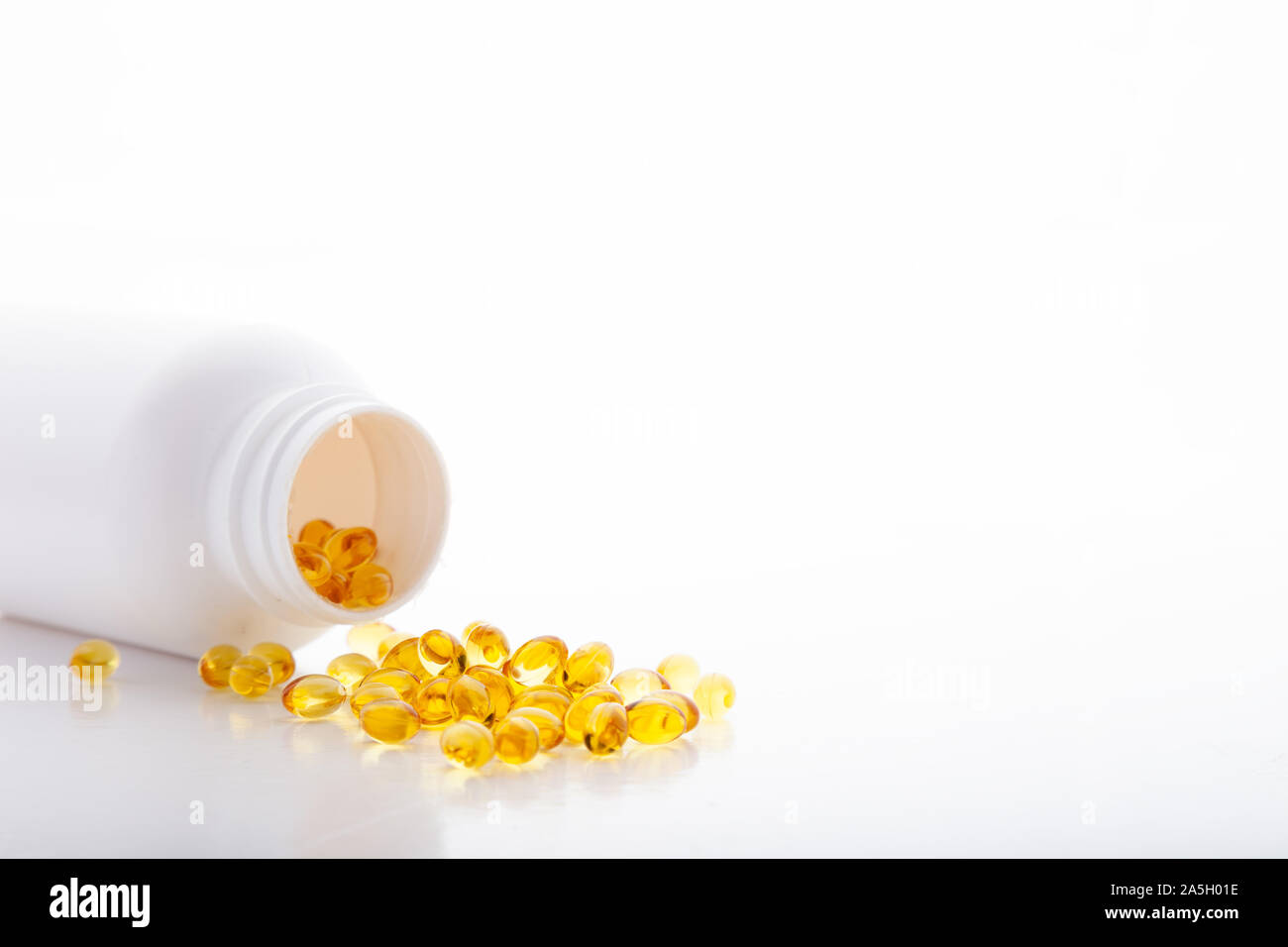 Top view of Gold fish oil scattered from pill bottle isolated for good ...