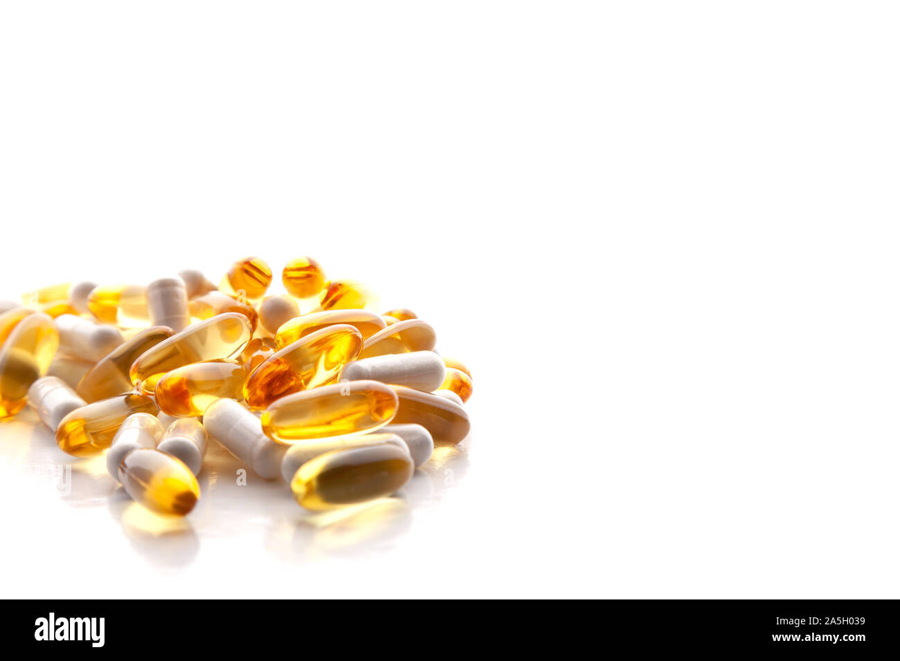 Tablets, pills, capsules, drugs pouring out of white bottle on white ...