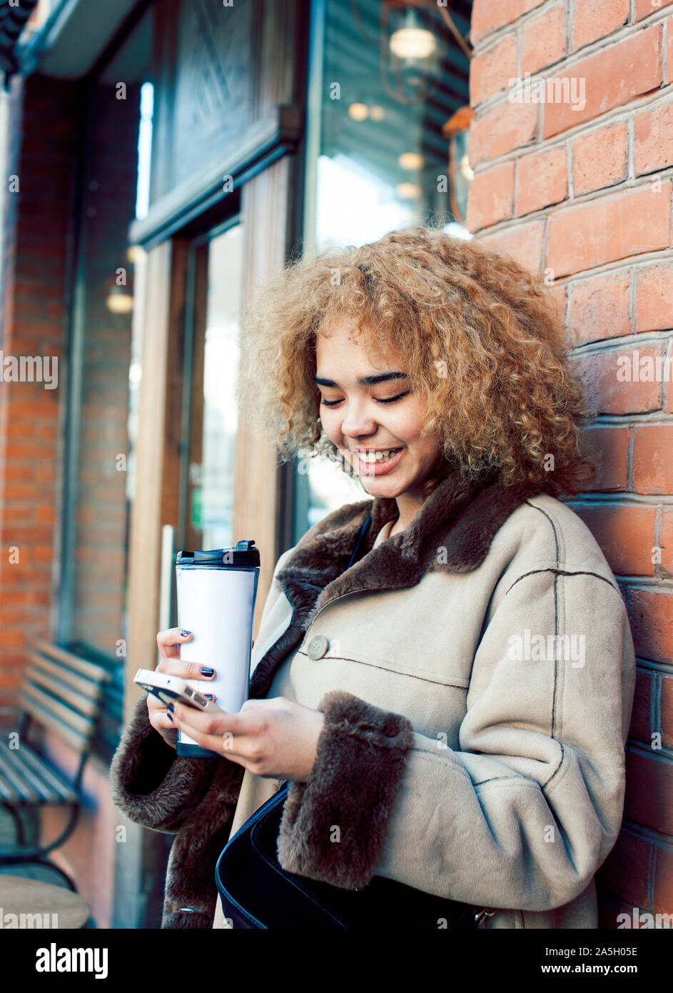 young pretty african american women drinking coffee outside in cafe ...