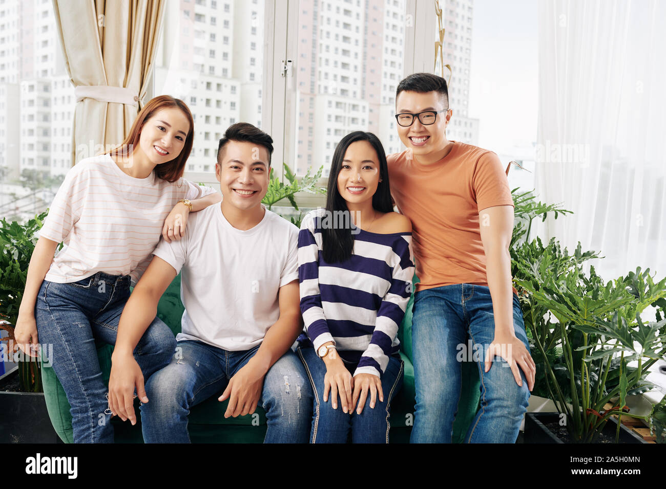 Two happy young Asian couples in casual clothes spending time together ...