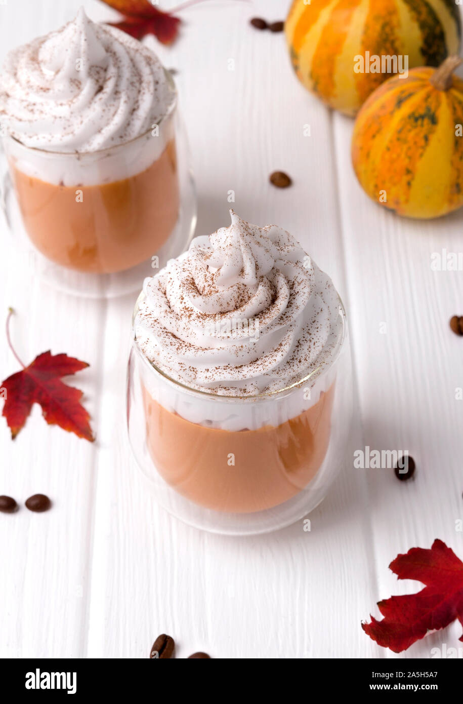 Cocktail with whipped cream on top on white wooden background with copy ...