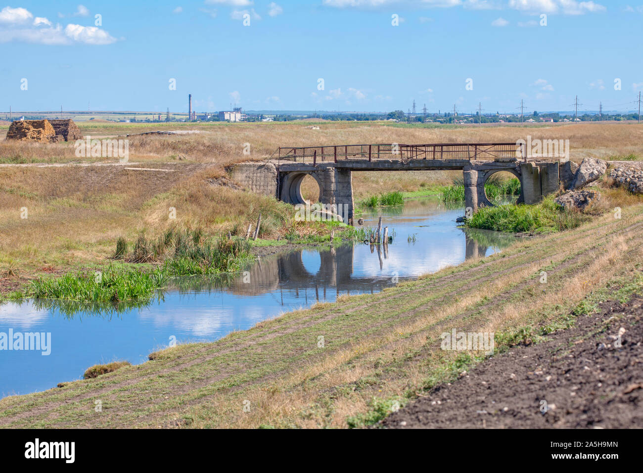 rustic summer with little river and bridge Stock Photo - Alamy
