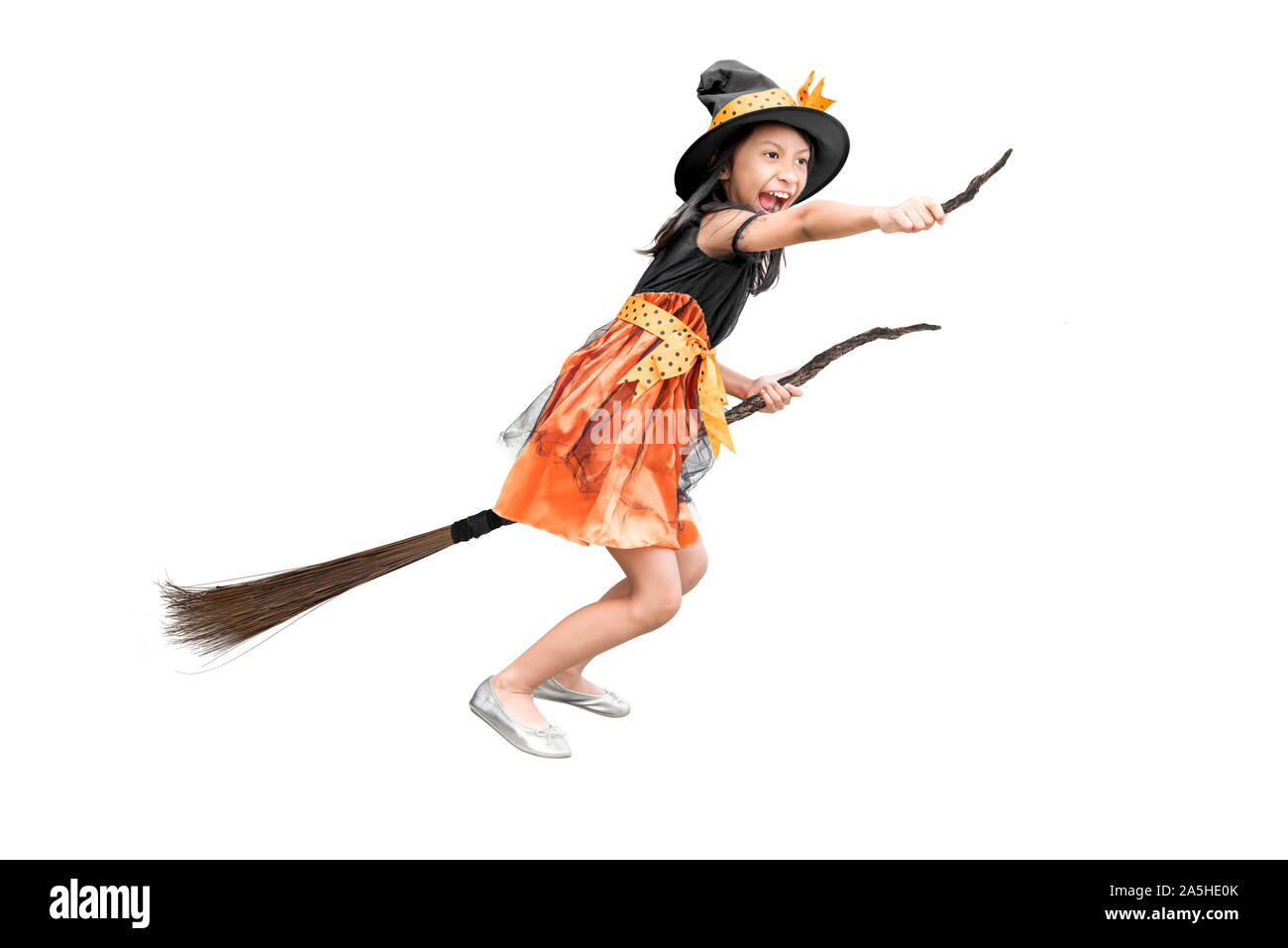 Asian little girl with witch costume using a magic wand and broom ...