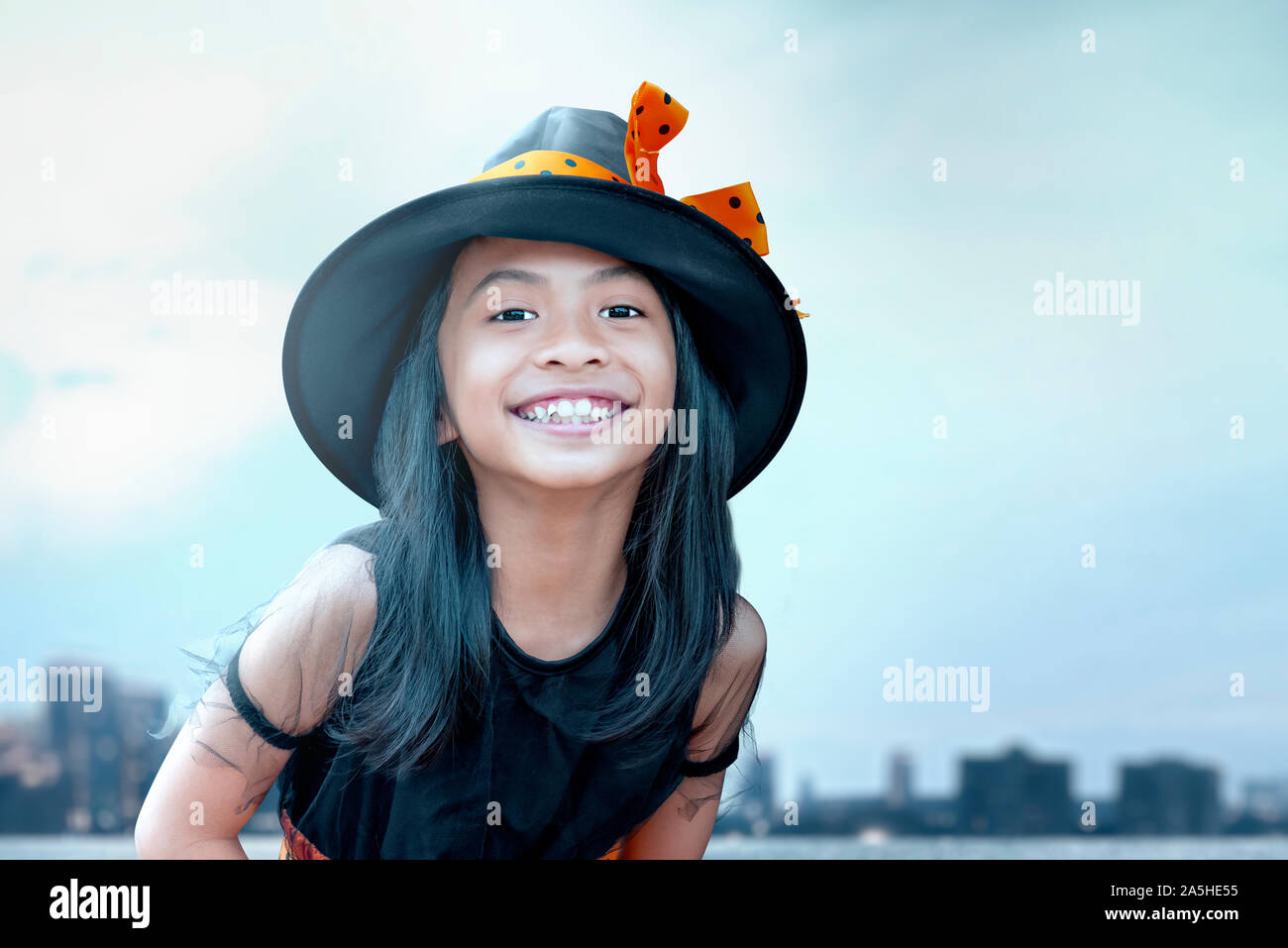 Asian child girl with witch costume and hat for Halloween over ...