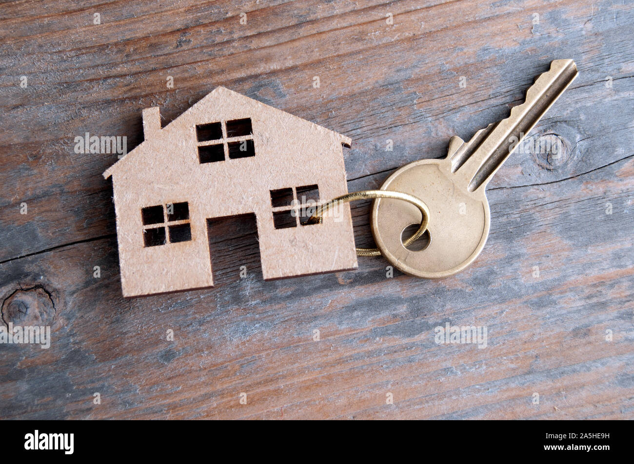 Key attached to a miniature wooden house Stock Photo - Alamy