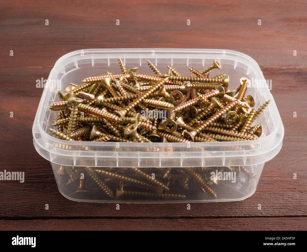 Group of steel screws in box on light brown background. Industrial ...