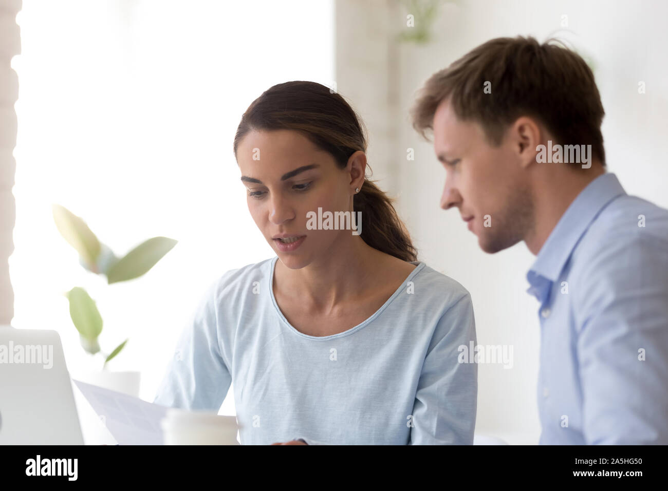 Millennial mixed race concentrated female employee working with ...