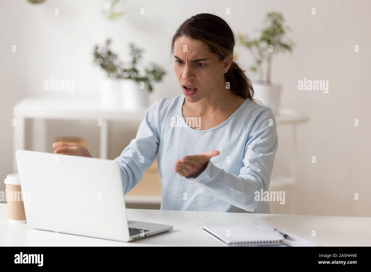 Angry millennial female worker employee irritated by slow computer work ...