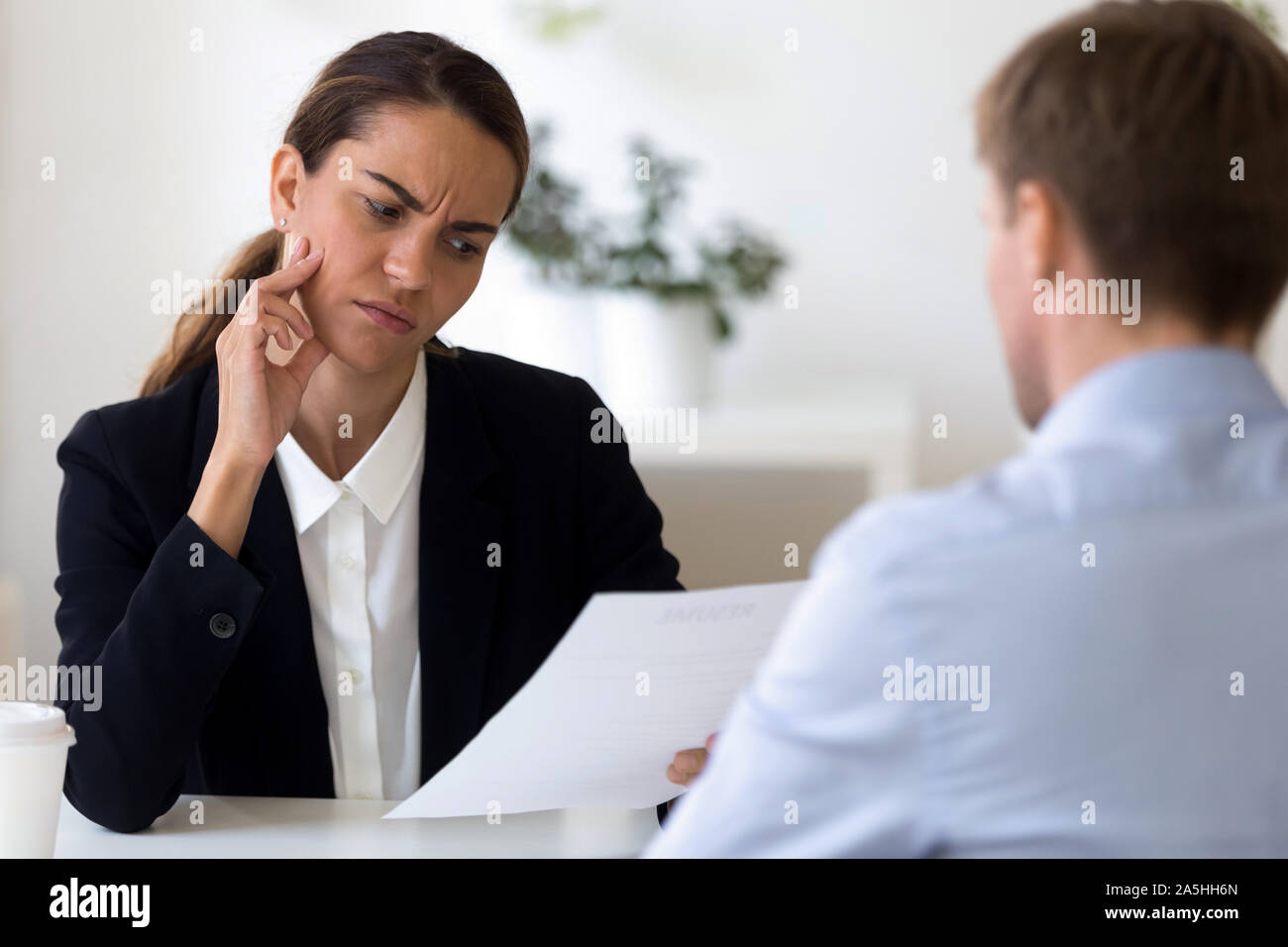 Doubtful mixed race female human resources manager looking through ...