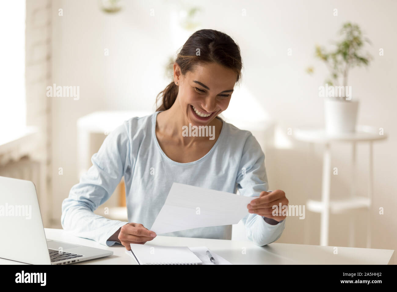 Happy young mixed race lady reading letter with good news Stock Photo ...