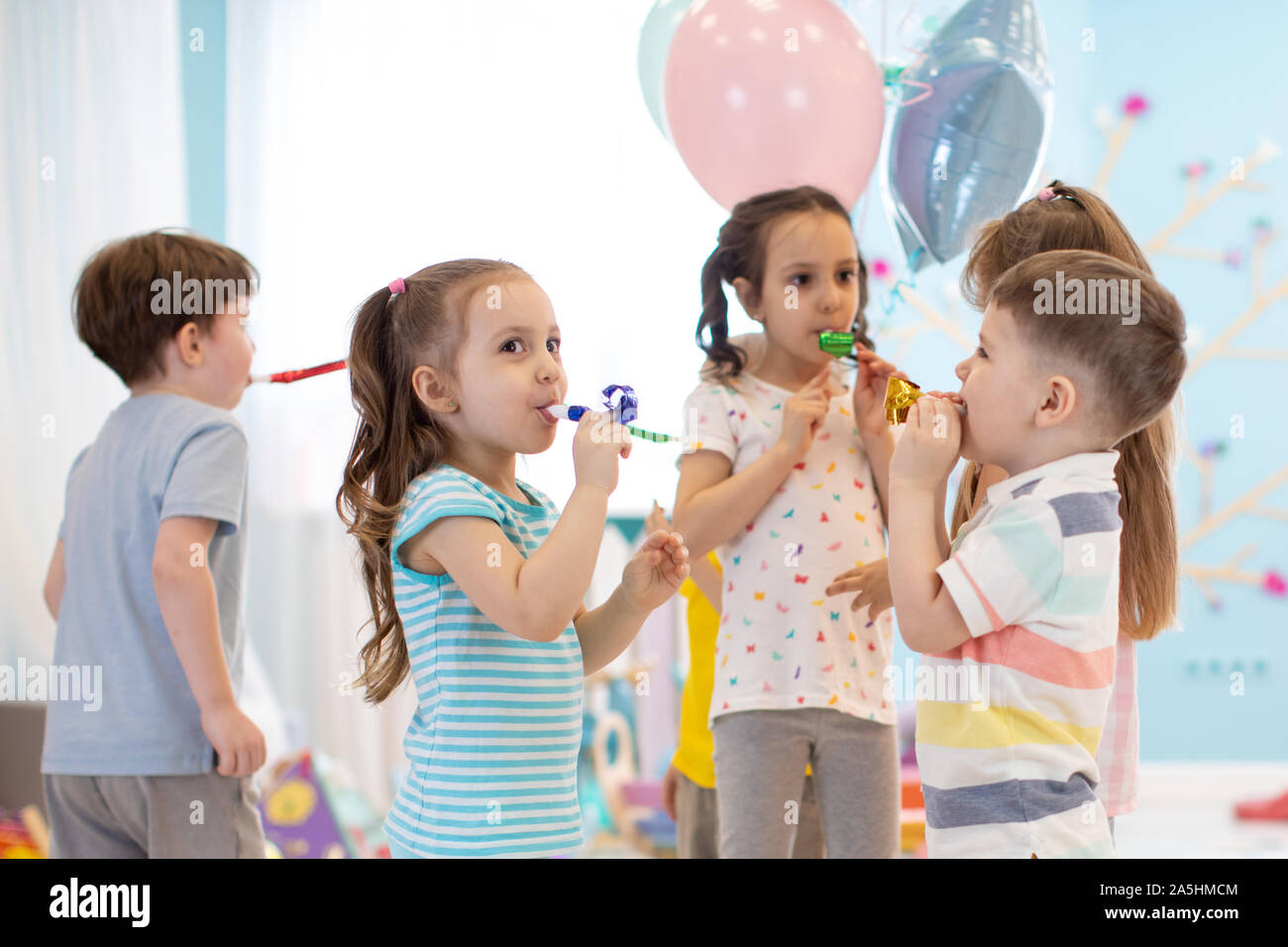 Children celebrating birthday party with noisemakers in club Stock ...