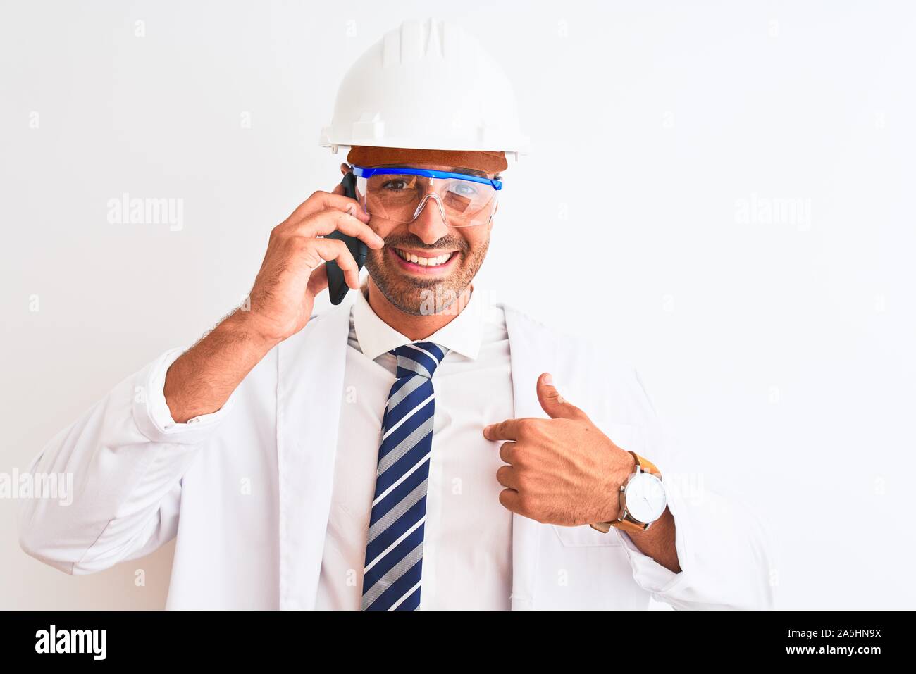 Young scientist man wearing safety helmet and calling using smartphone ...