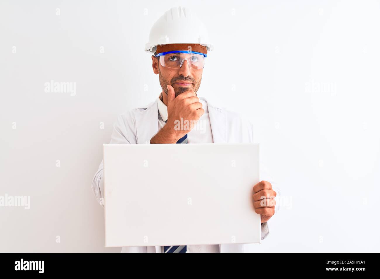Young chemist man wearing security helmet holding signboard over ...