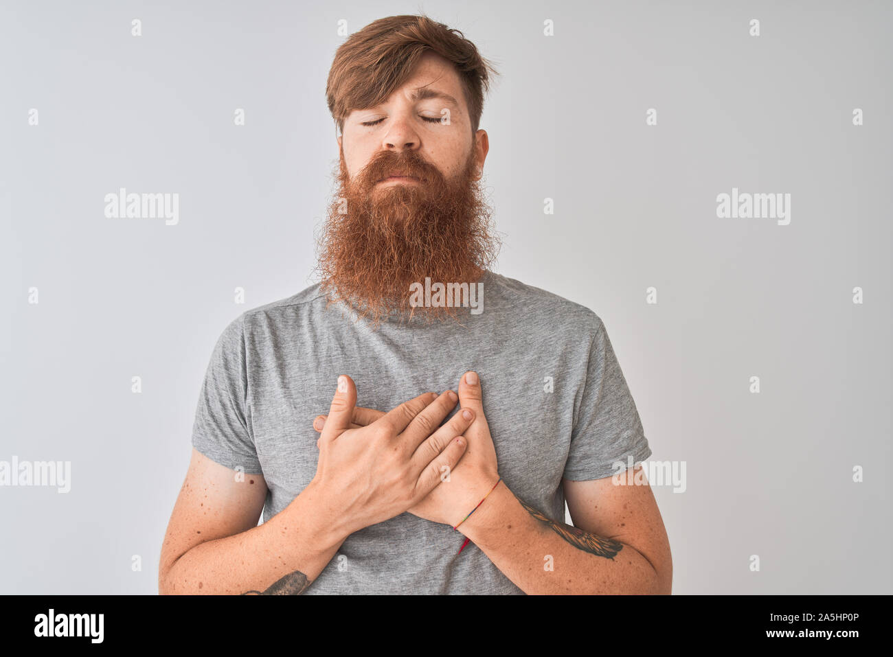 Young redhead irish man wearing t-shirt standing over isolated grey ...