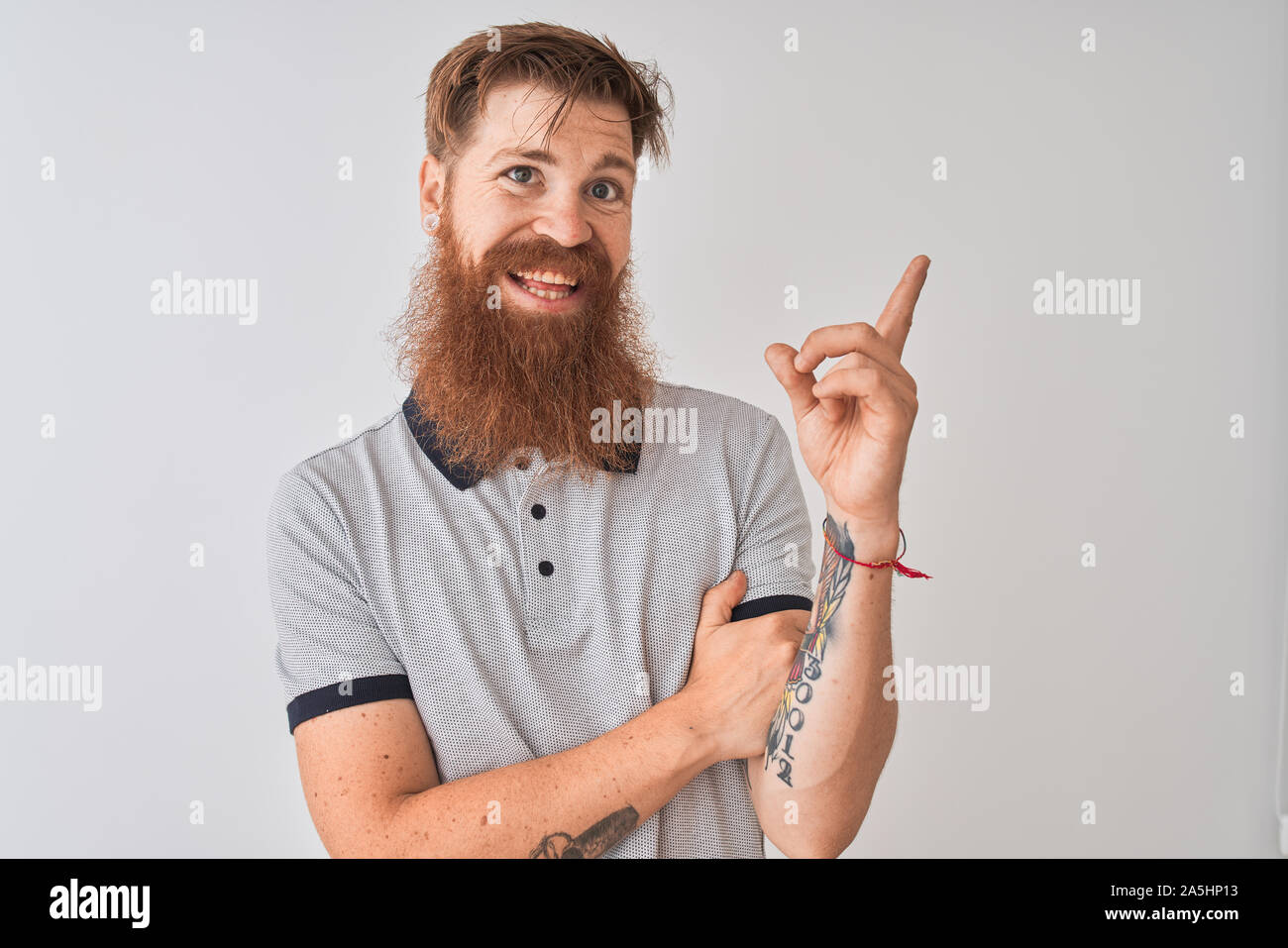 Young redhead irish man wearing grey polo standing over isolated white ...