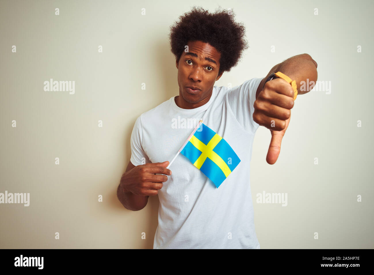 Young afro american man holding Sweden Swedish flag standing over ...