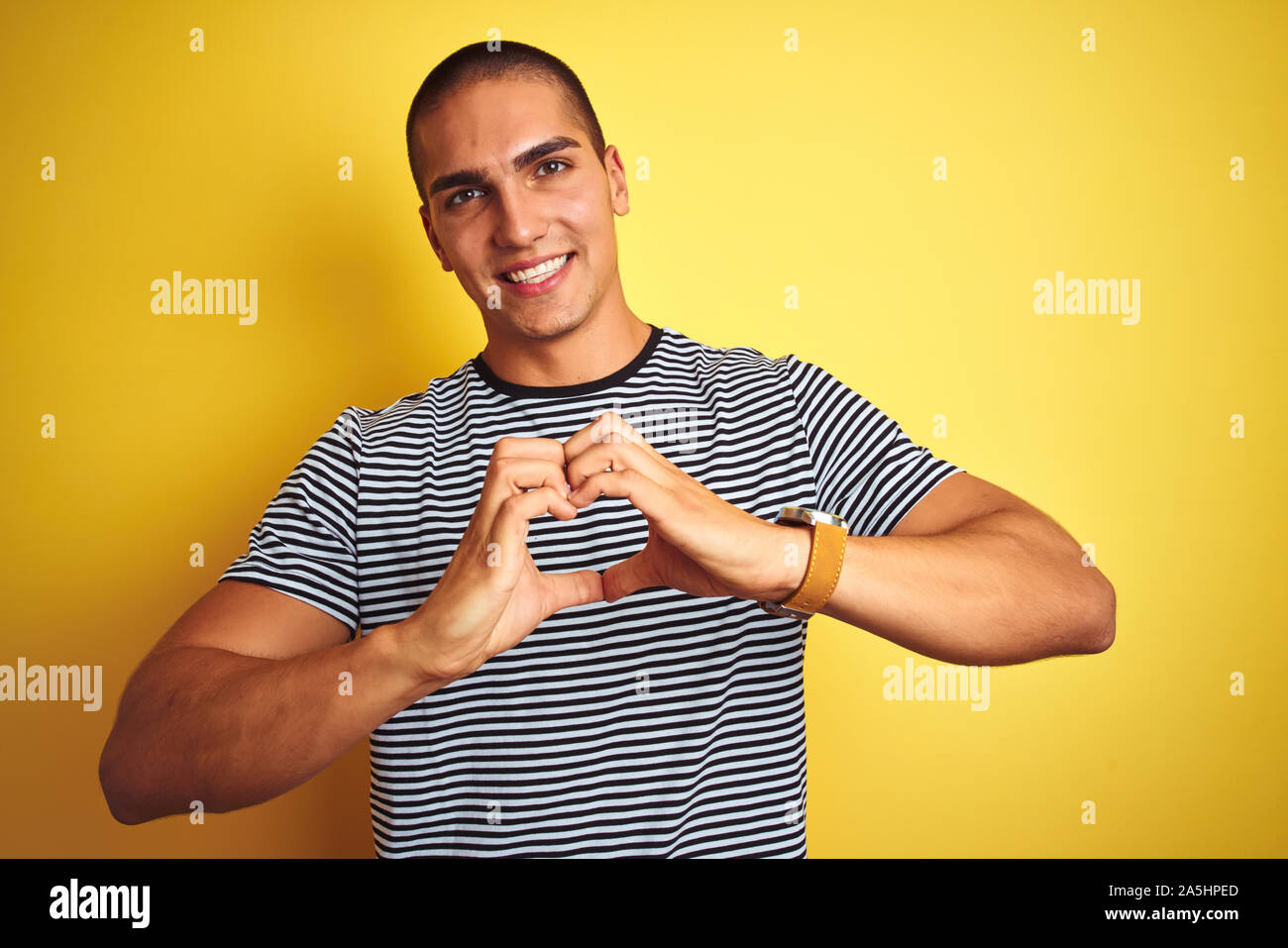 Young Handsome Man Wearing Striped T Shirt Over Yellow Isolated