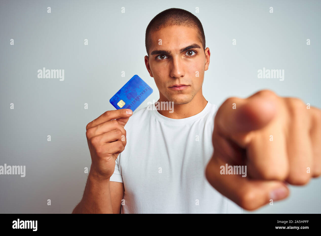 Young handsome man holding credit card over white isolated background ...