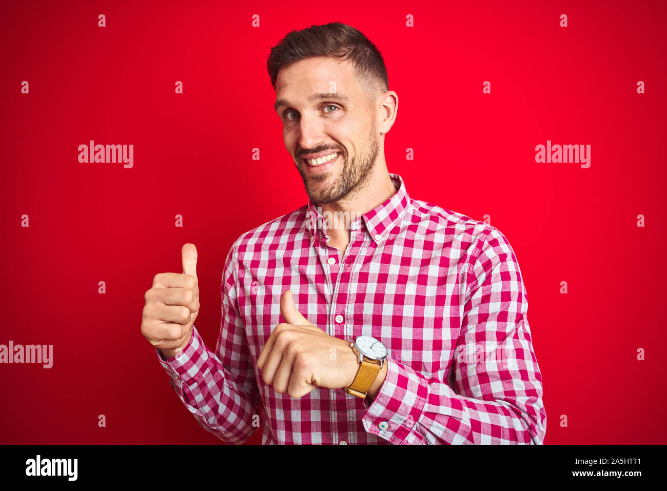 Young handsome man over red isolated background Pointing to the back ...