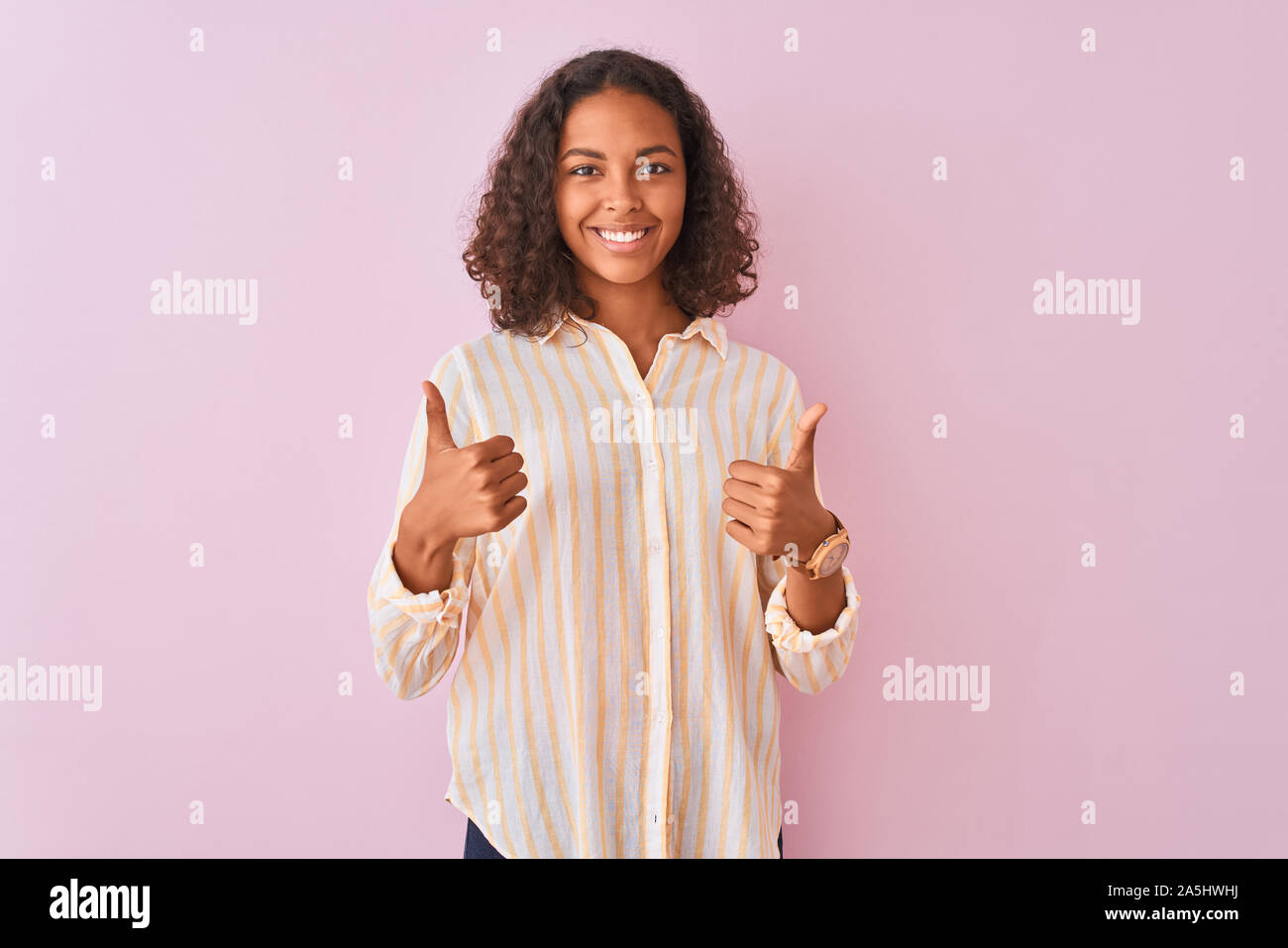 Young Brazilian Woman Wearing Striped Shirt Standing Over Isolated Pink