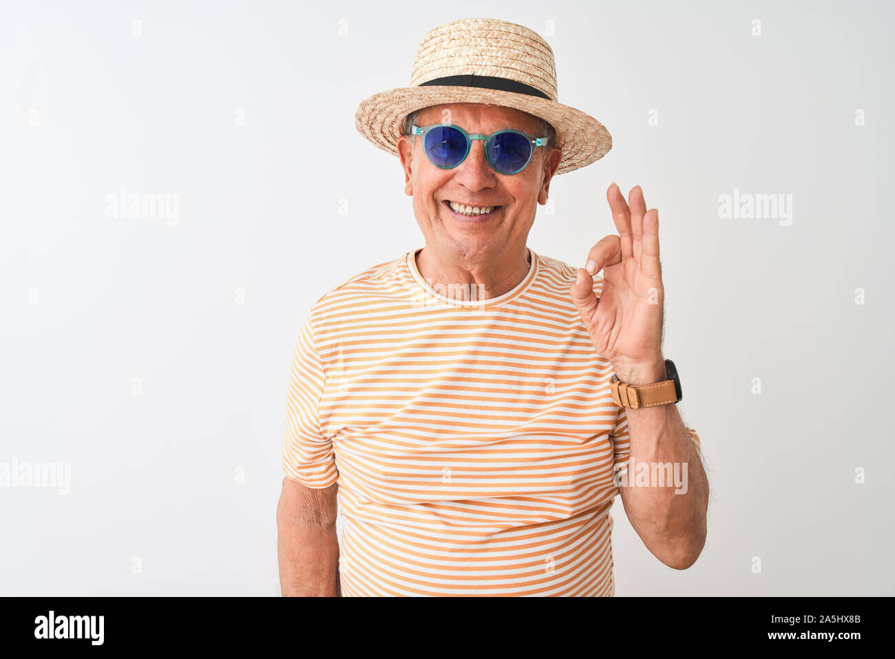 Senior man wearing striped t-shirt sunglasses and sumer hat over ...