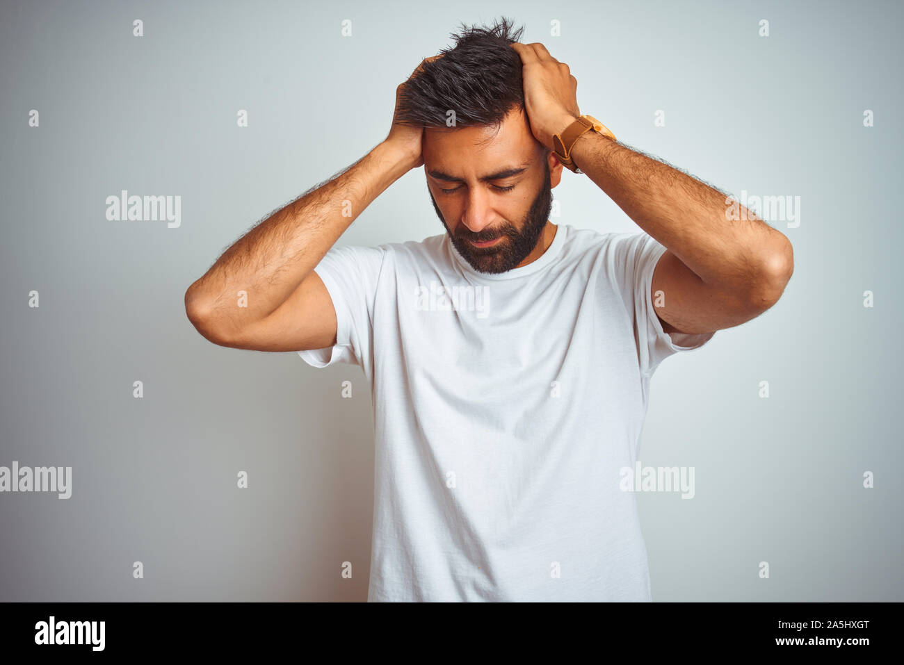 Young indian man wearing t-shirt standing over isolated white ...