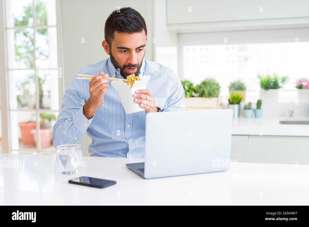 Business man eating asian food from delivery while working using ...