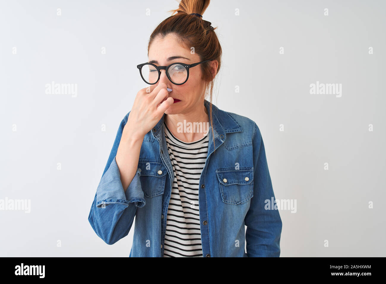 Redhead woman wearing striped t-shirt denim shirt and glasses over ...