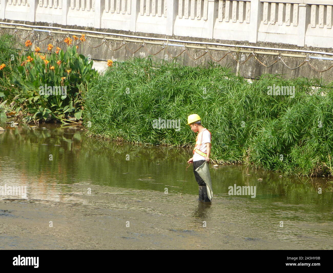 Sanitation workers clean up rubbish in rivers, in Xixiang River ...