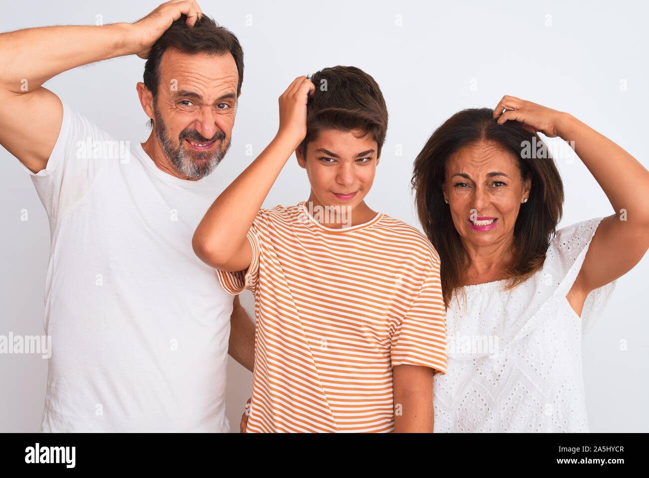 Family of three, mother, father and son standing over white isolated ...
