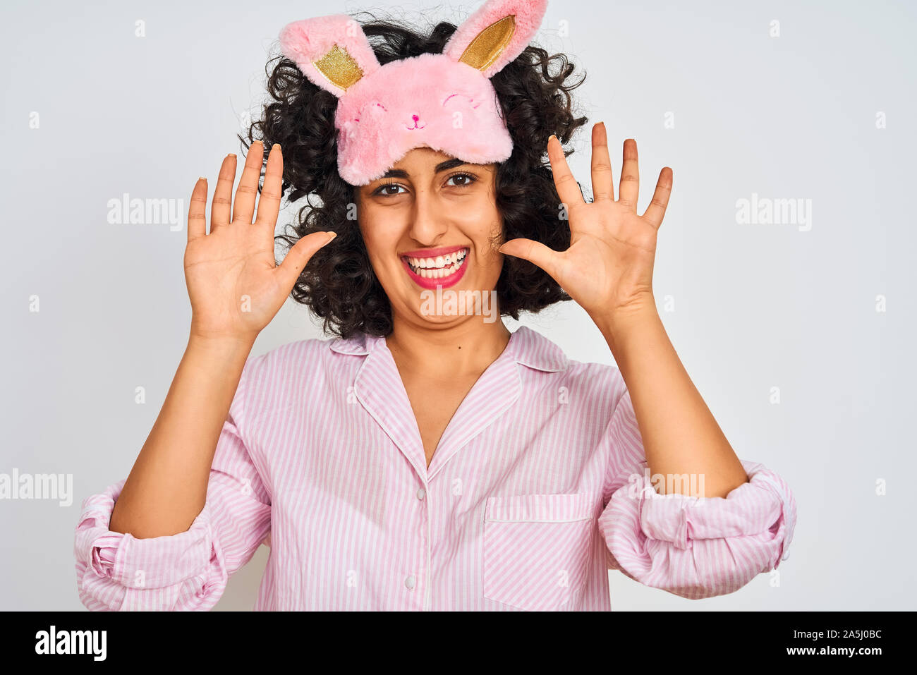 Arab Woman With Curly Hair Wearing Pajama And Sleep Mask Over Isolated