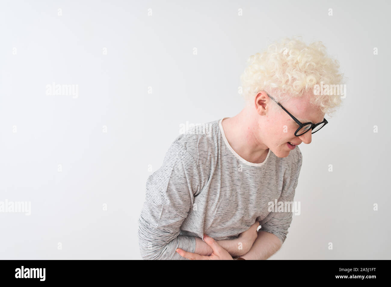 Young albino blond man wearing striped t-shirt and glasses over ...