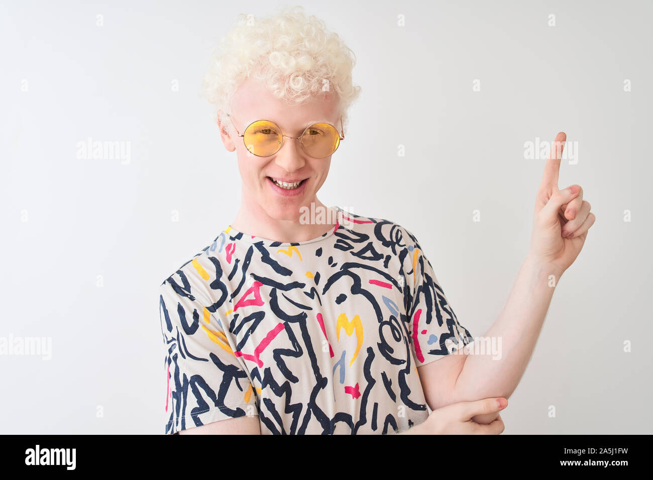 Young albino blond man wearing colorful t-shirt and sunglasses over ...