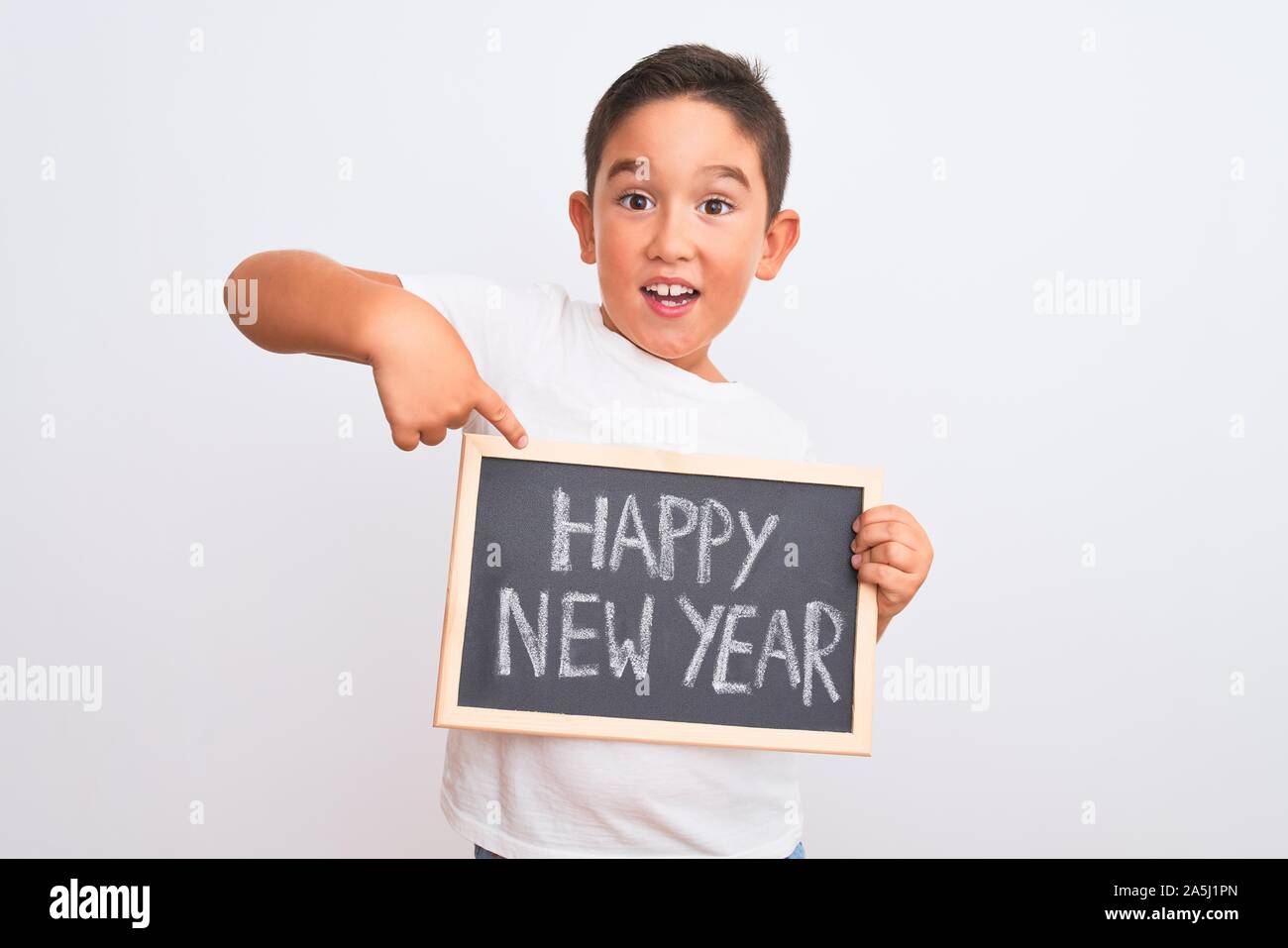 Beautiful kid boy holding blackboard standing over isolated white ...
