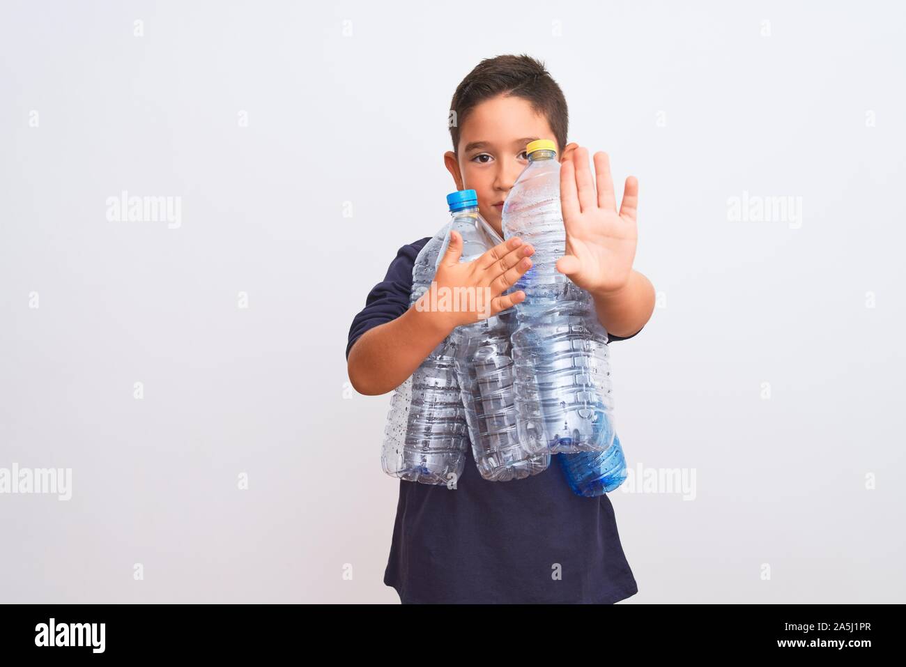 Beautiful kid boy recycling plastic bottles standing over isolated ...