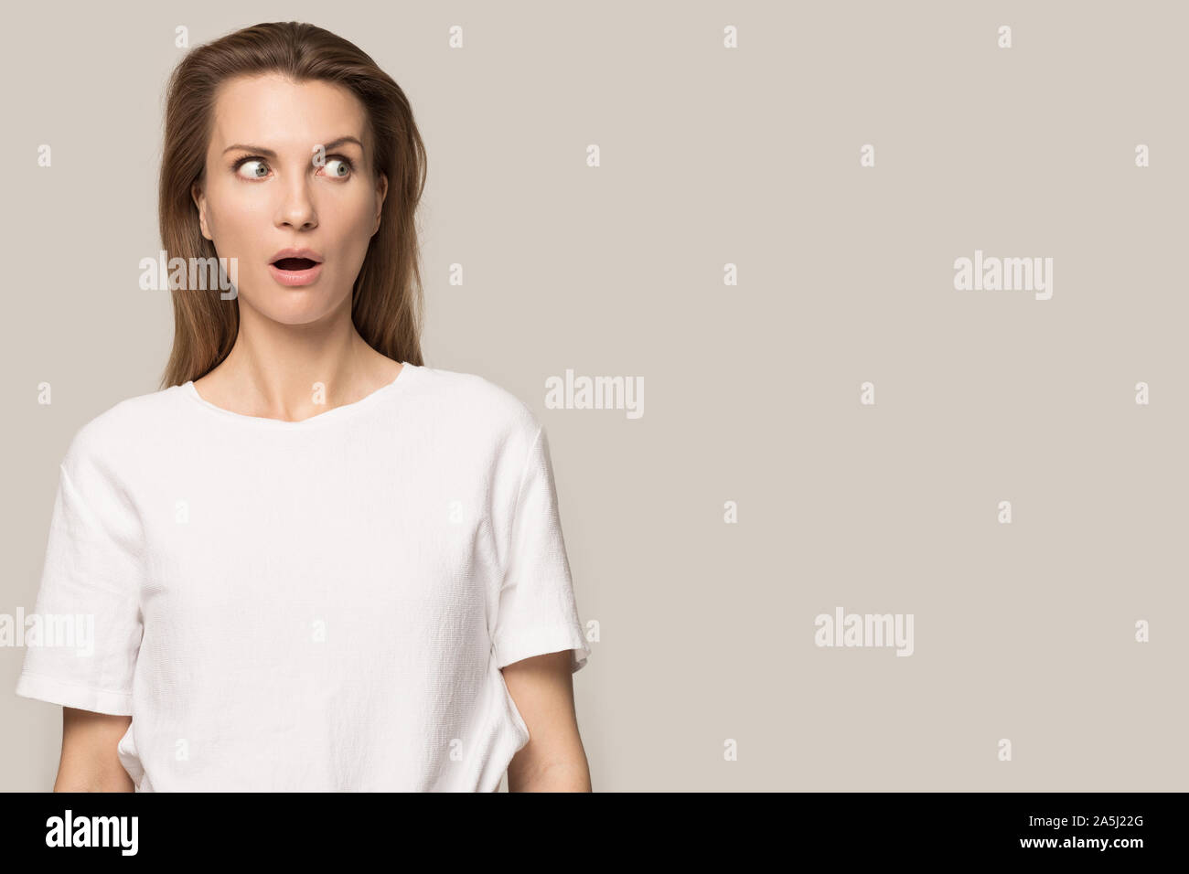 Shocked millennial woman peep at blank copy space Stock Photo - Alamy