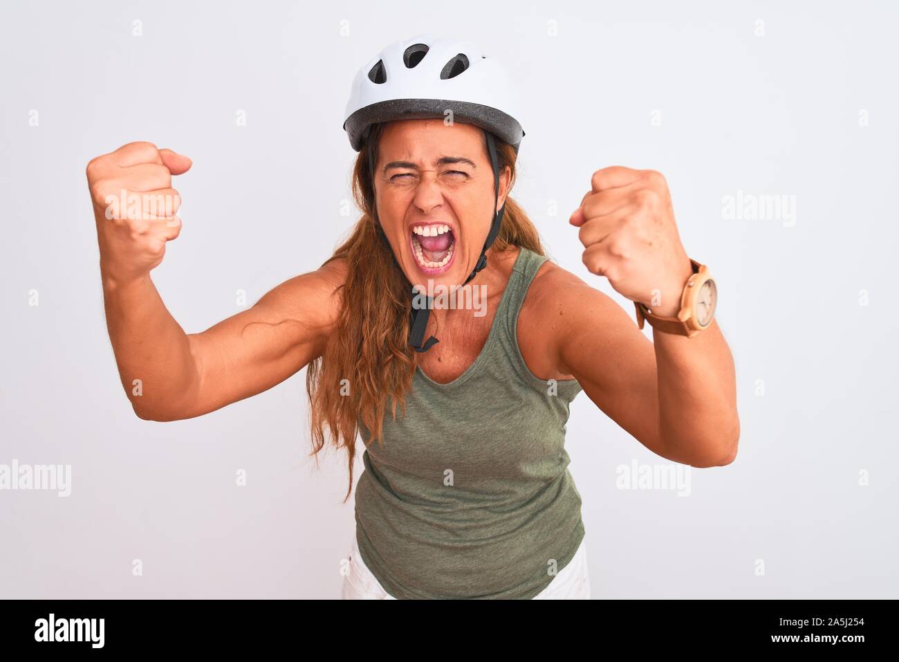 Middle age mature cyclist woman wearing safety helmet over isolated ...
