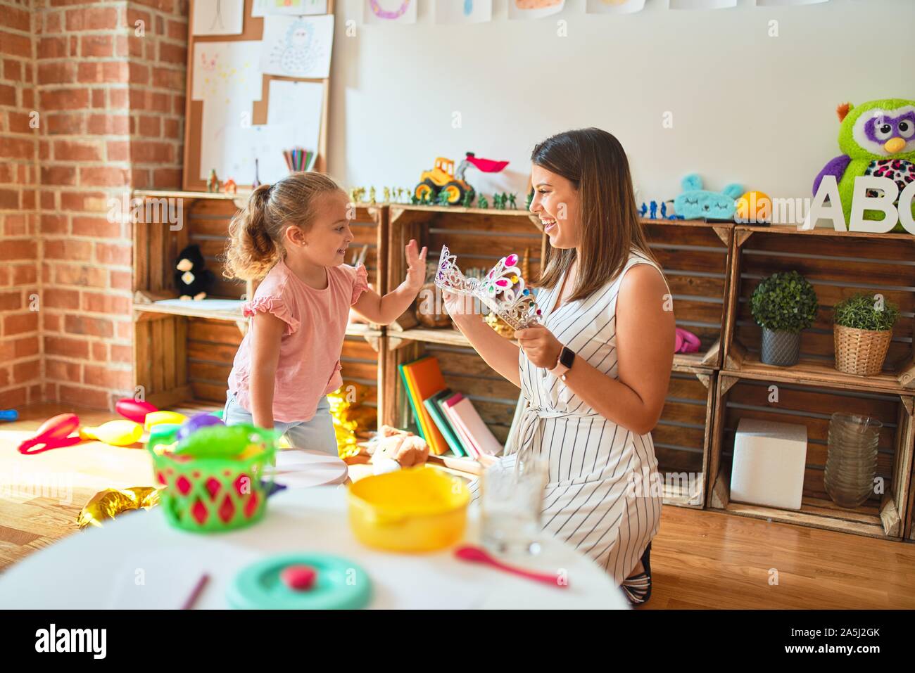 Beautiful teacher and blond student toddler girl playing to be a ...