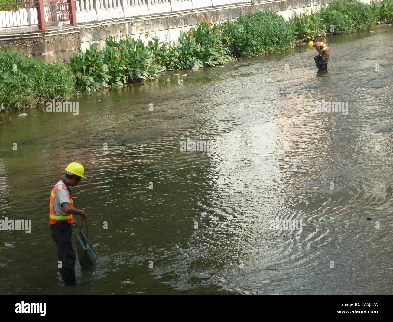 Sanitation workers clean up rubbish in rivers, in Xixiang River ...